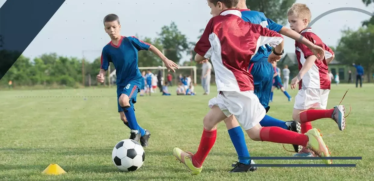 Il piede e la caviglia del bambino che gioca a calcio
